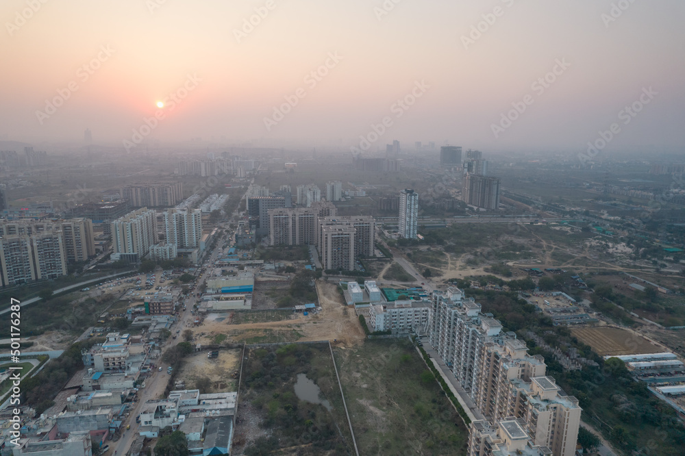 aerial drone shot passing over a building with homes, offices, shopping ...