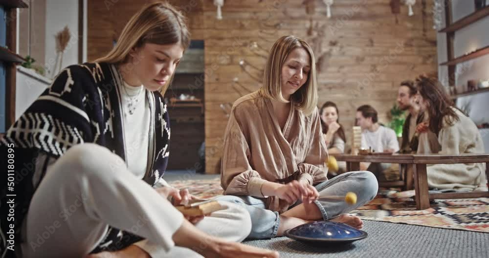 Women playing percussion instruments together. Relaxed female hippies ...
