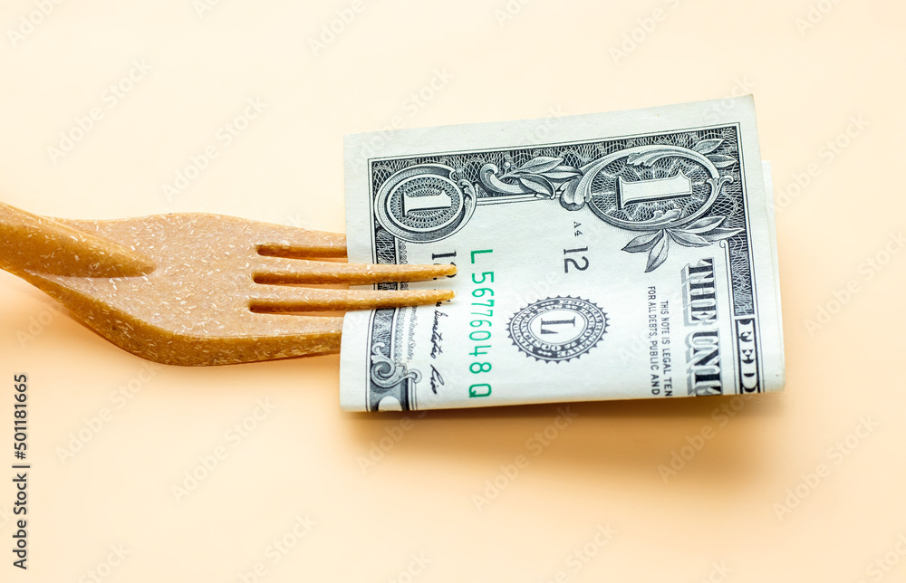 one dollar bill in the tines of a fork made from recycled materials on ...