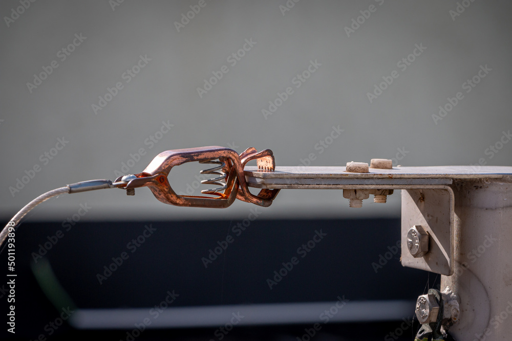 Copper ground terminal clamped to a metal plate, suitable for ...