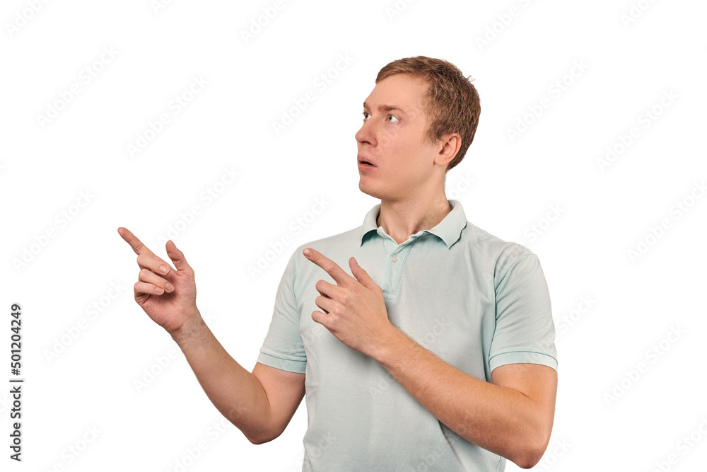 Surprised man with funny face in grey T-shirt pointing finger to left ...
