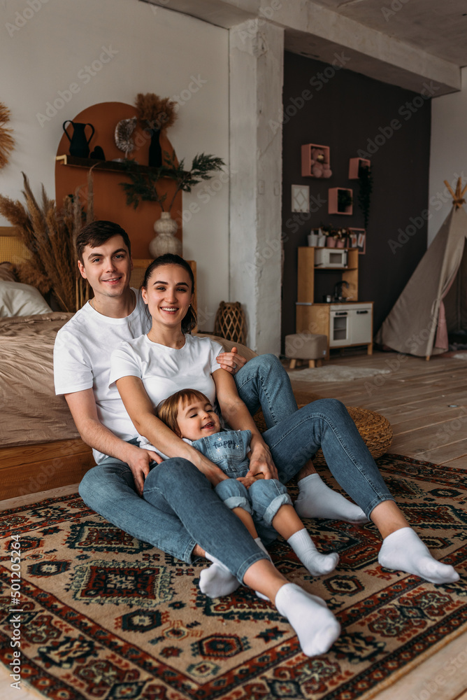 A happy young family spends time together in a home interior. A ...