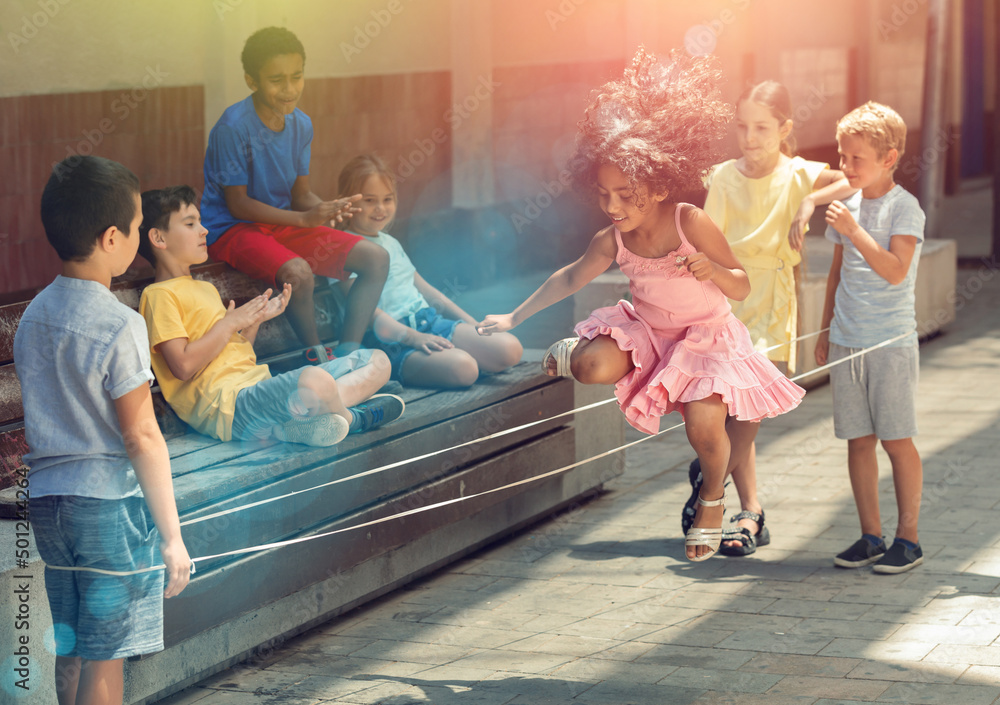 Happy peruvian little girl jumping game by rubber band with european ...