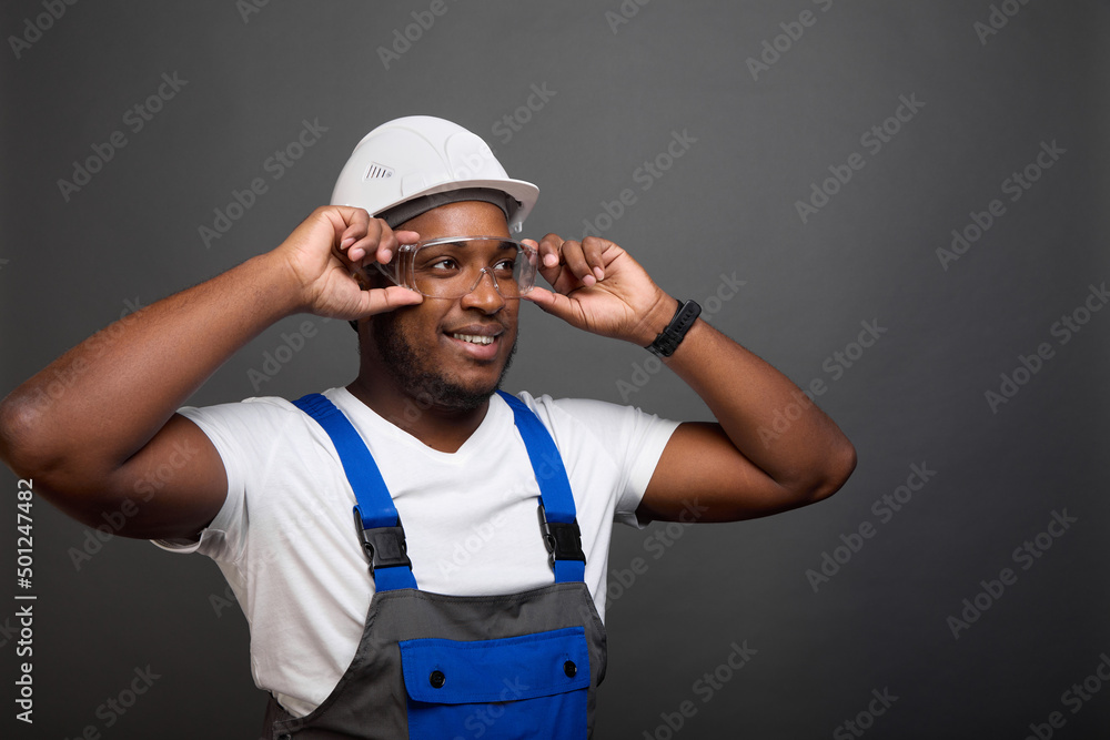 A modern professional architect carefully adjusts his goggles while on ...