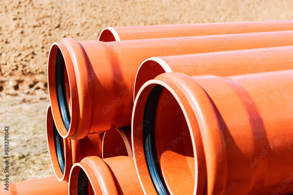 Orange sewer pipes at the construction site. Preparation for the ...