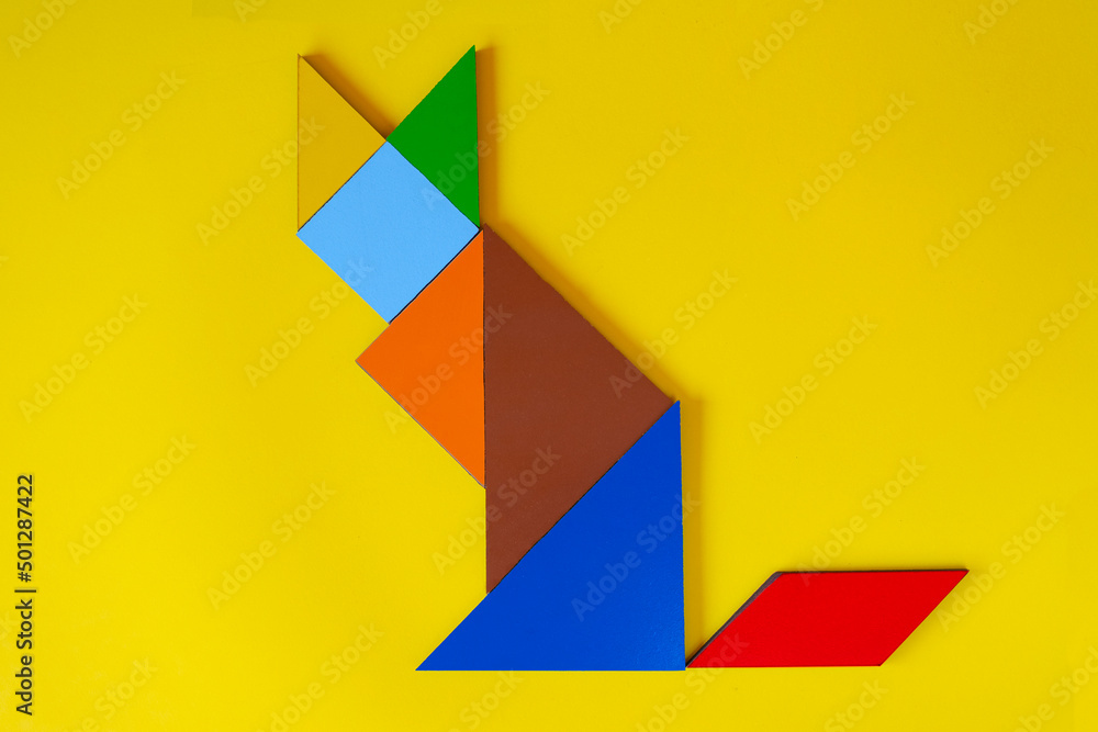 Tangram cat, top view of tangram animal cat, lay down, isolated on yellow background, colorful ...
