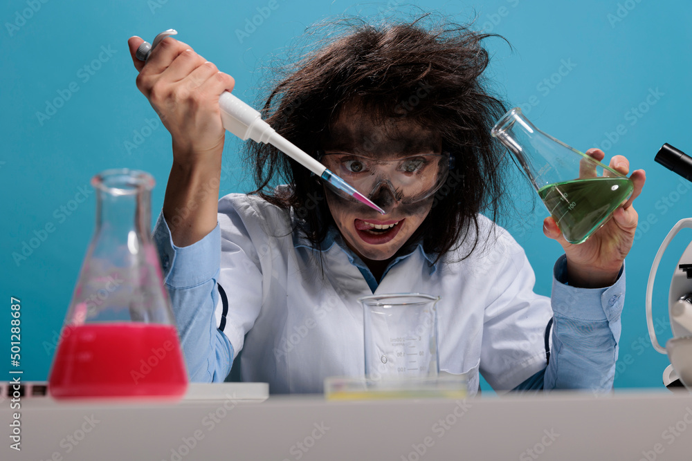 Foolish silly female lab worker with pipette and glass jar mixing toxic ...
