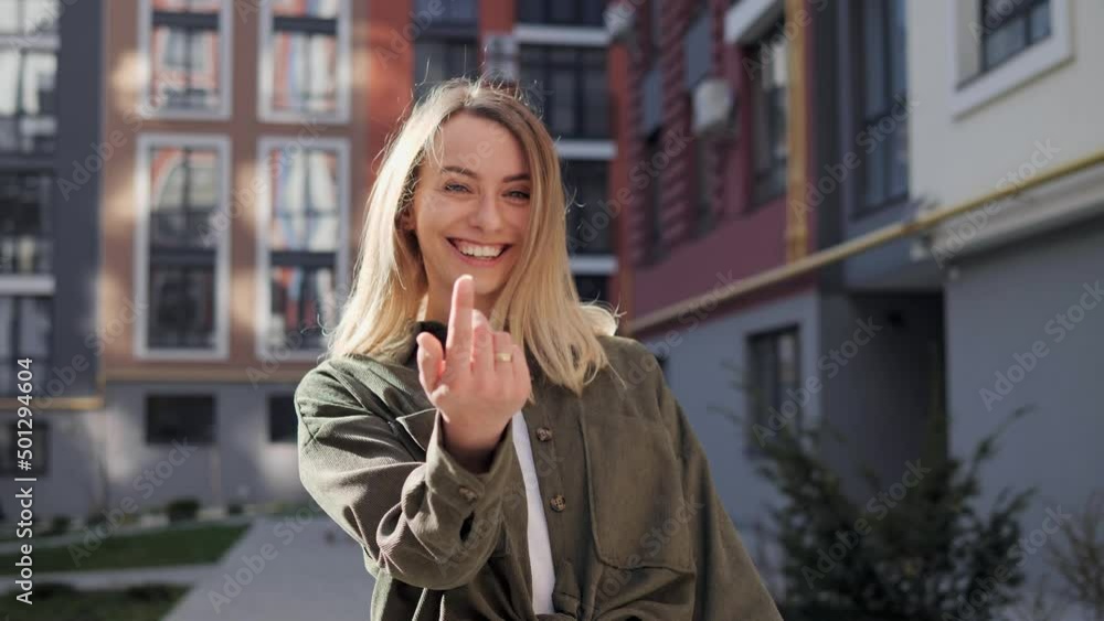 Gorgeous girl waving hand to come with me on city street. Come here ...
