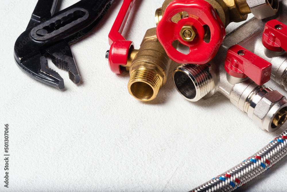 Plumbing equpment parts and wrench on the white background close up ...