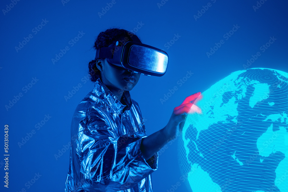 Woman wearing virtual reality simulator touching earth on screen ...