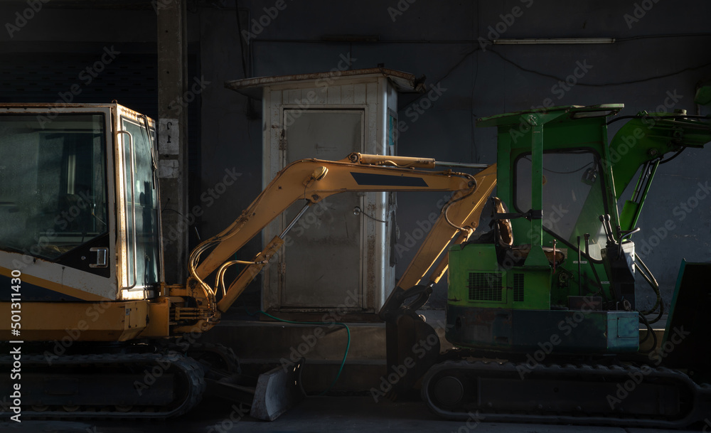 Two construction excavators of yellow and green color for the ...
