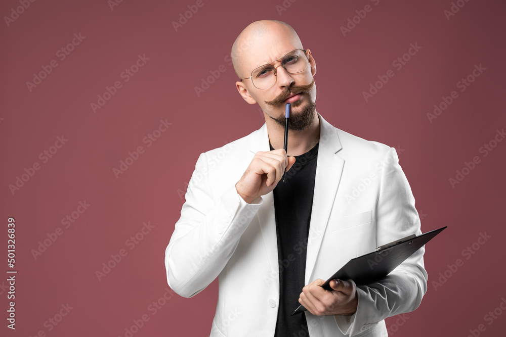 Balded man with mustache and beard in a business suit holding clipboard ...