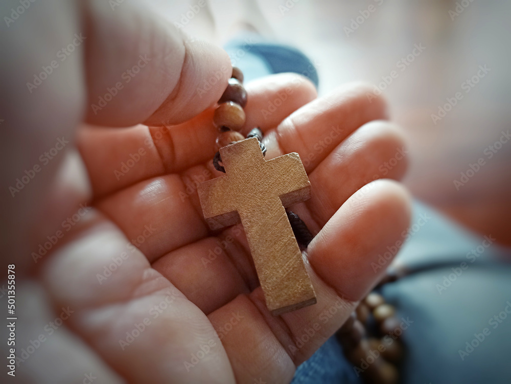 Cross in hands. Person holding wooden holy cross of rosary in hand ...