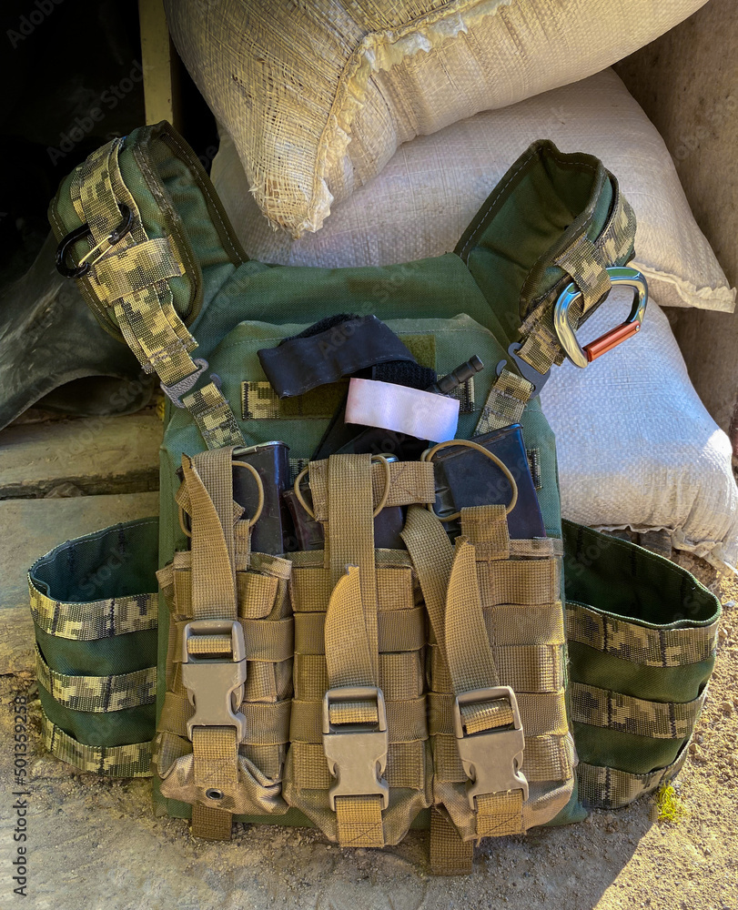 Military body armor on the background of a military trench. Body armor ...