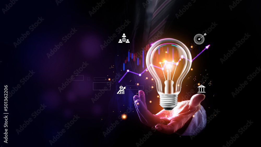 Businessman holding a bright light bulb on neon purple background ...