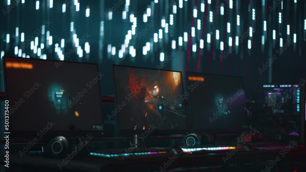 Powerful computers with shooter game on screens in neon cyber games ...