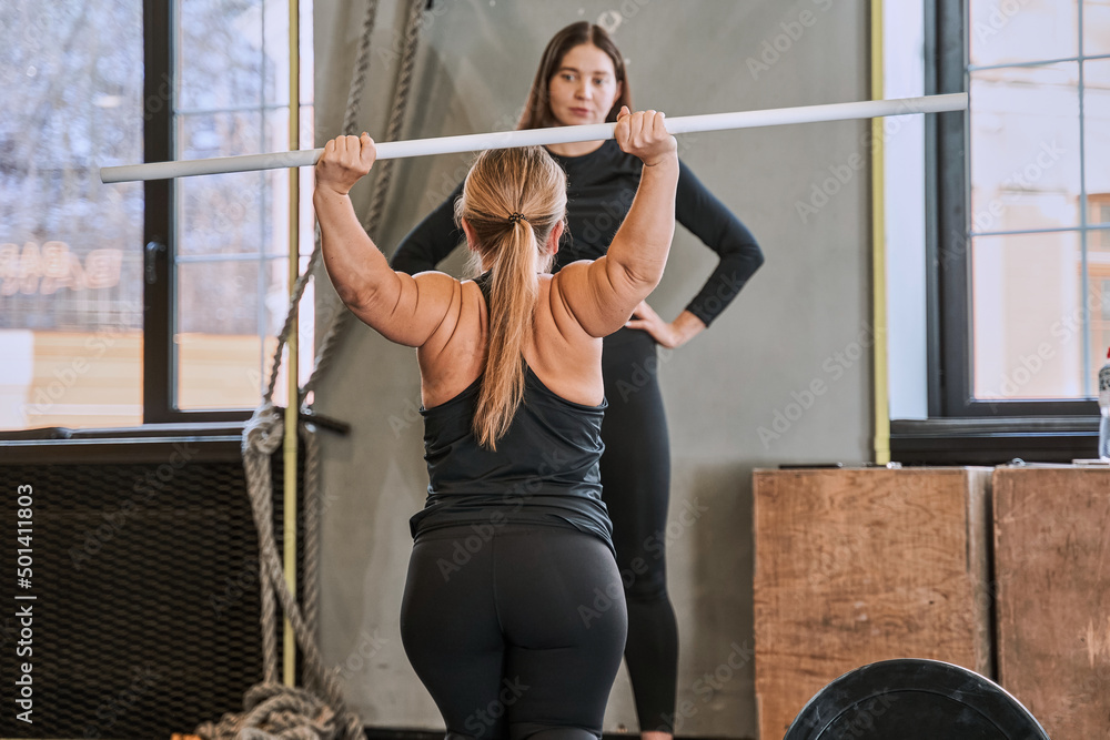 Fitness woman with perfect muscular body training body in gym with her ...