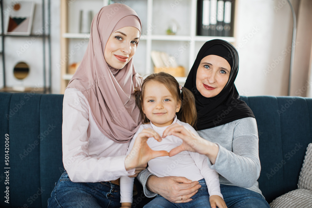 Portrait of smiling three generations of muslim women have fun posing ...