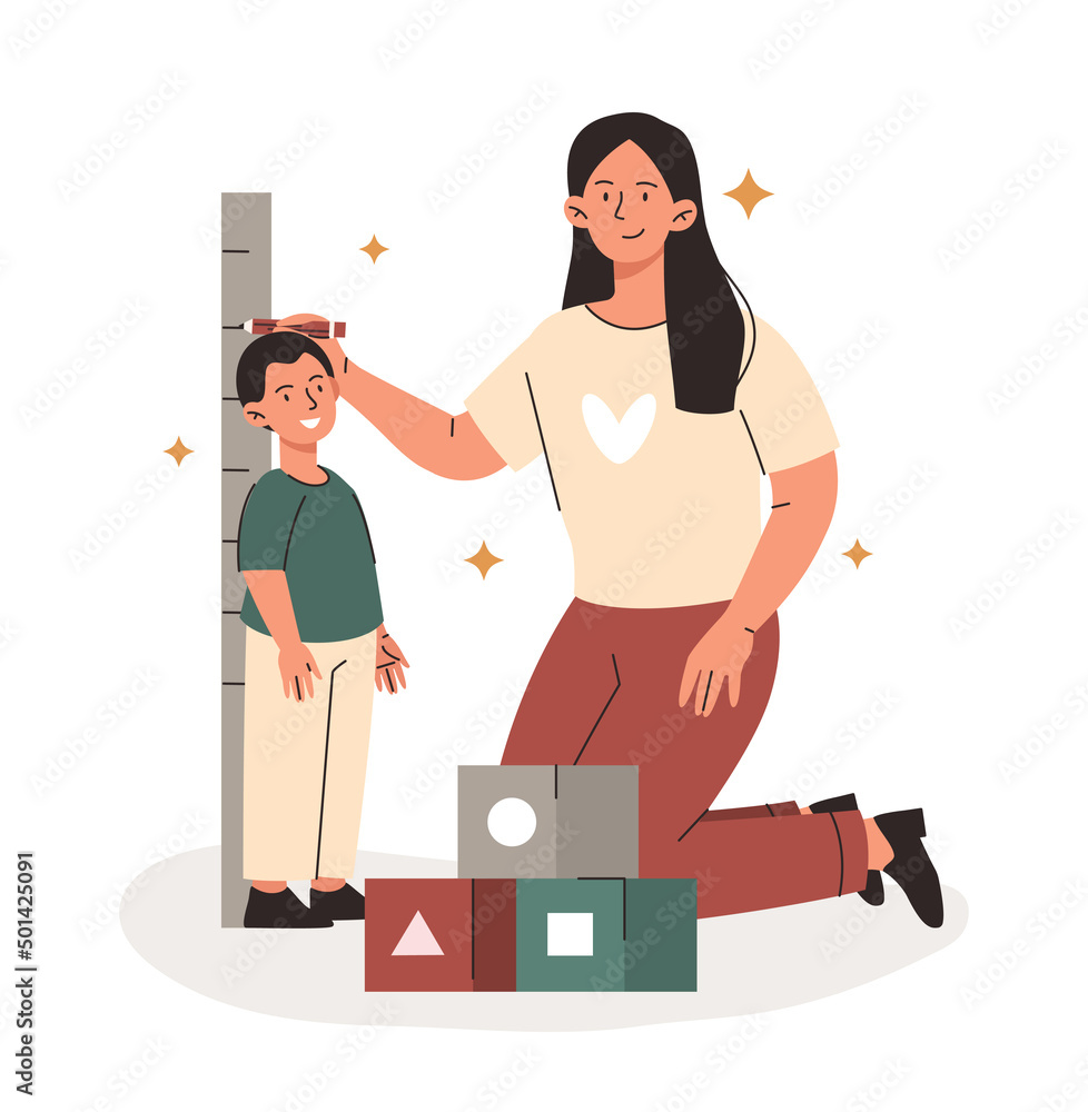 Mother measuring her son height against wall. Young smiling woman plays ...