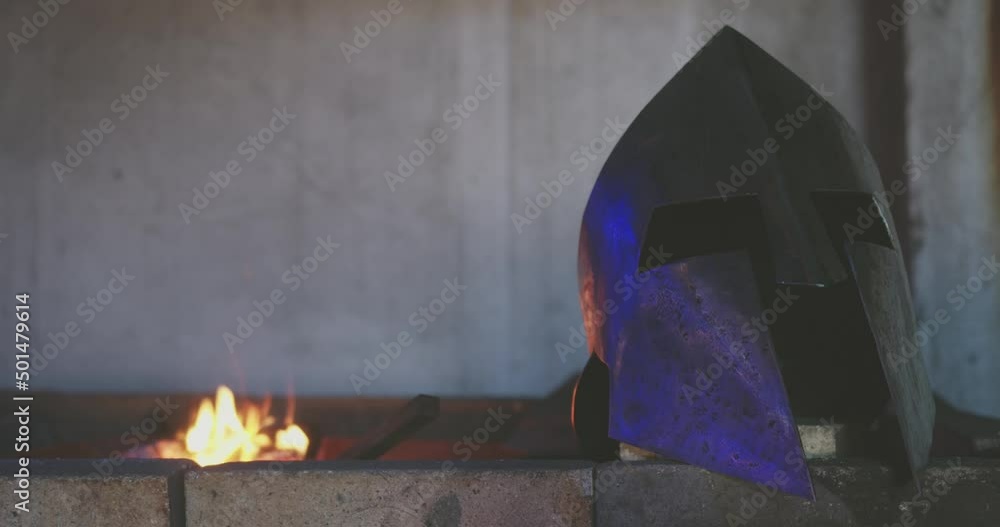 Close up of helmet of medieval times being forged in smithy. Mask for ...