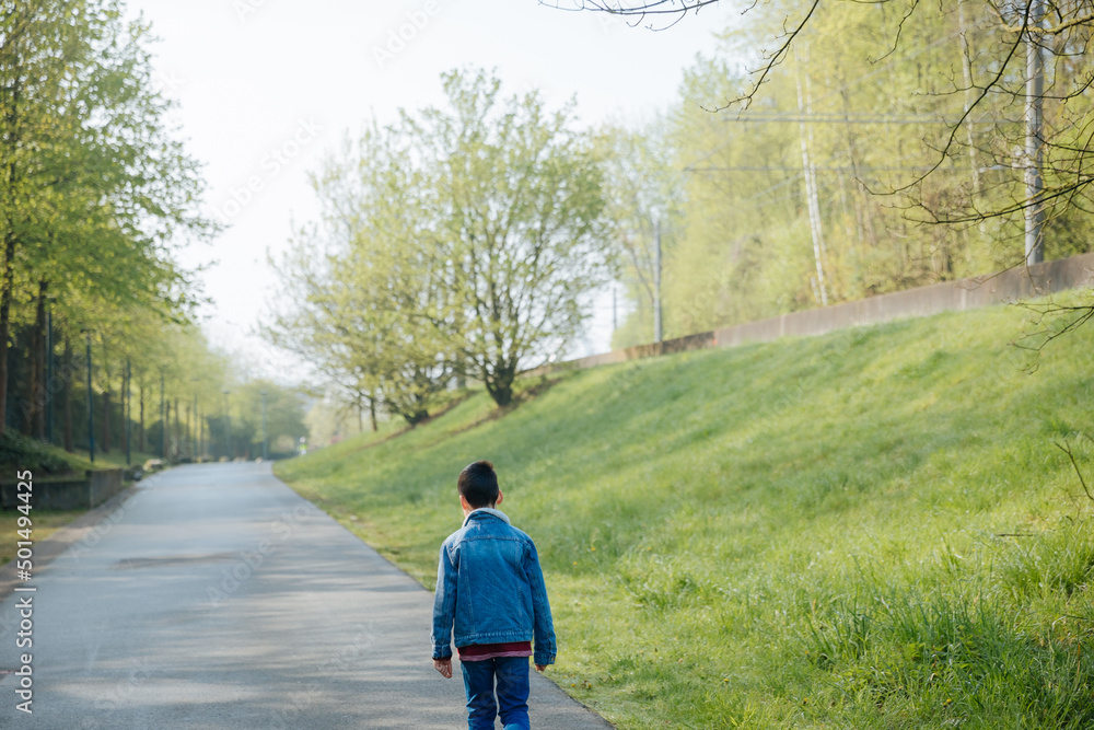 Child is walking alone in a park. The way to go to school alone ...