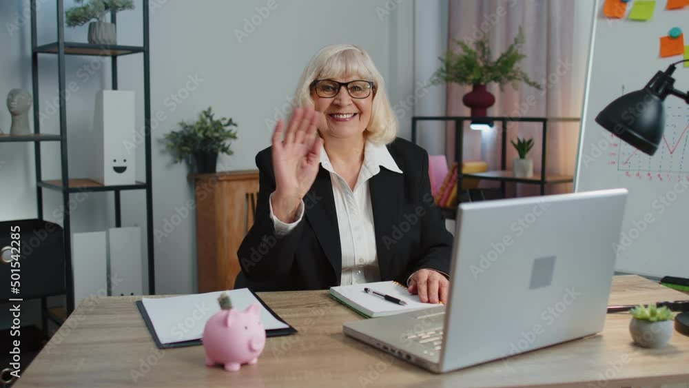 Hello. Senior business woman employee wears glasses waves hand palm in ...