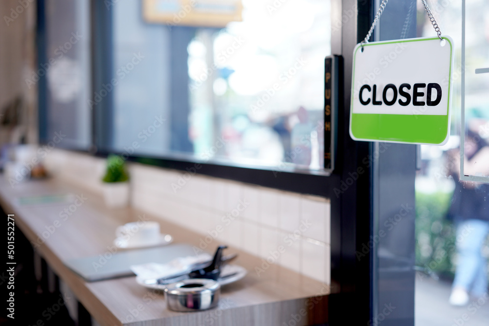 Open and closed flip sign in front of coffee shop and restaurant glass ...