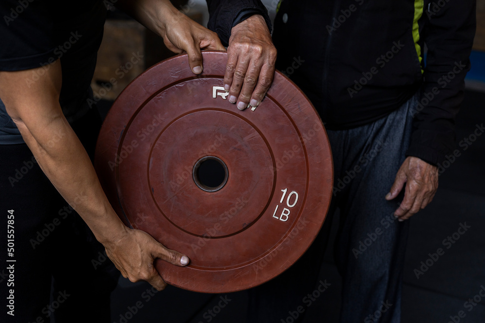 Unrecognizable Latin American elderly man and his trainer hold in their ...