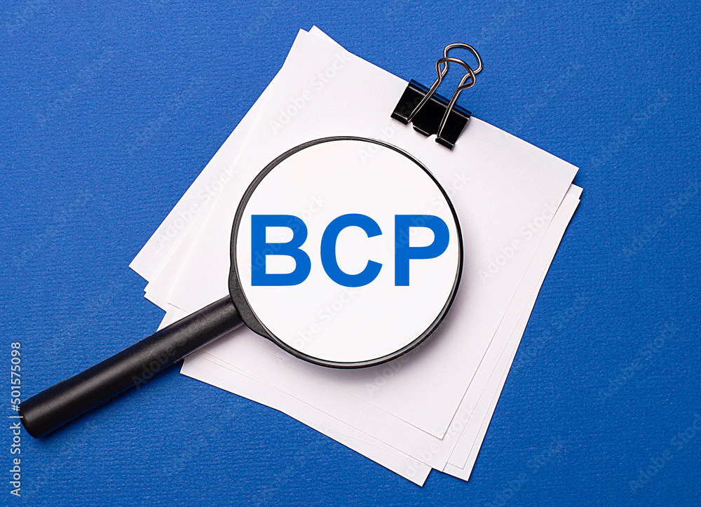 On a blue background, white sheets under a black paper clip and on them ...