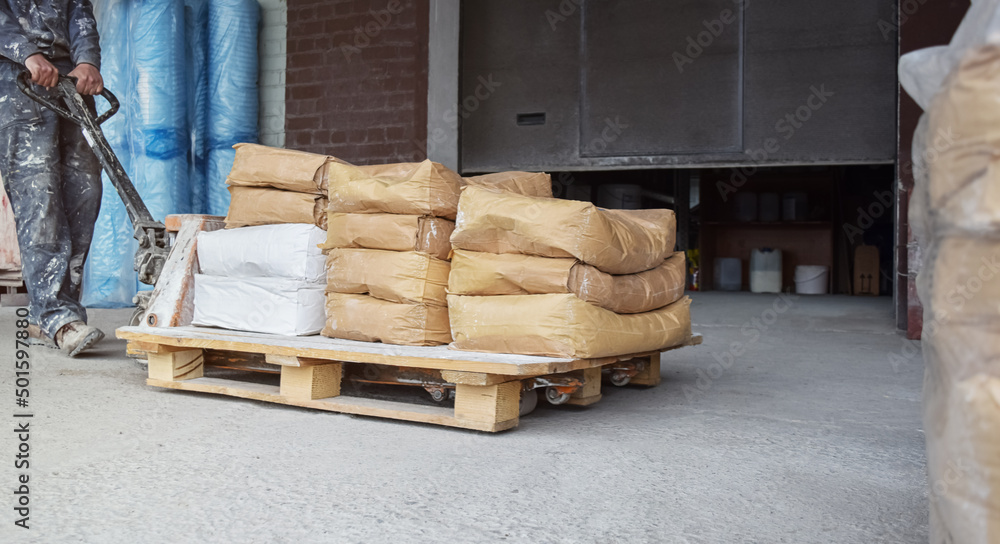 Production. Industrial workshops. The worker transports sacks filled ...