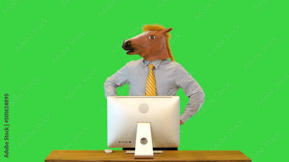 Thoughtful man in horse mask look at computer concerned rubbing head ...