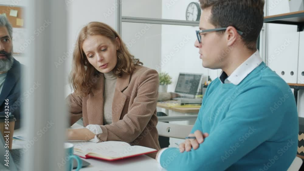 People colleagues speaking and checking information in notebook sitting ...