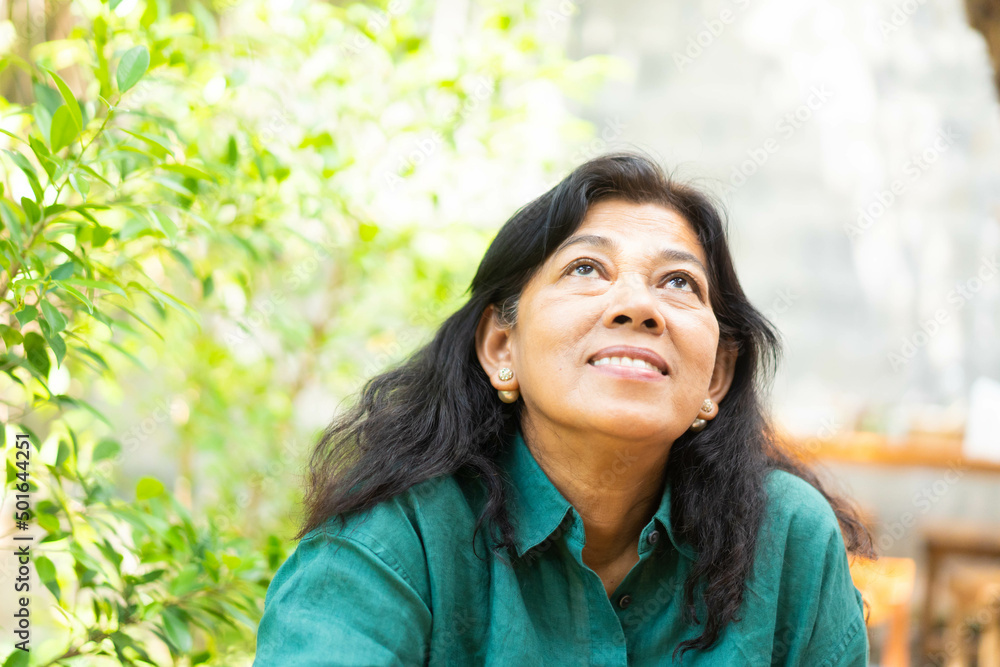 Portrait of asian old woman 60s smile looking camera on green nature ...