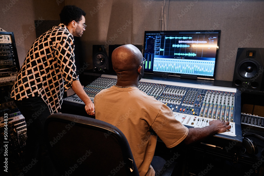 Mature African American producer and young singer creating music track ...
