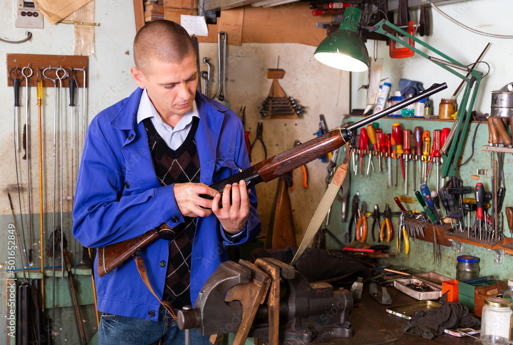 Foto de Gunsmith examines and checks appearance of the semi-automatic ...