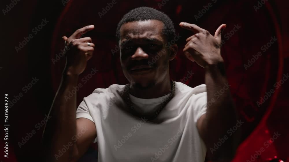 Black man teenage hip hop artist raps and waves his arms while ...
