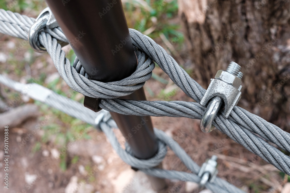 Interlocking steel cable secures a barrier on a mountain path. Stock ...