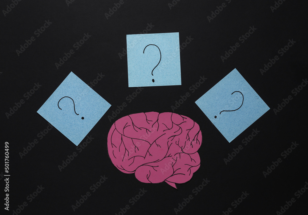 Paper cut brain and memo papers with question marks on black background ...