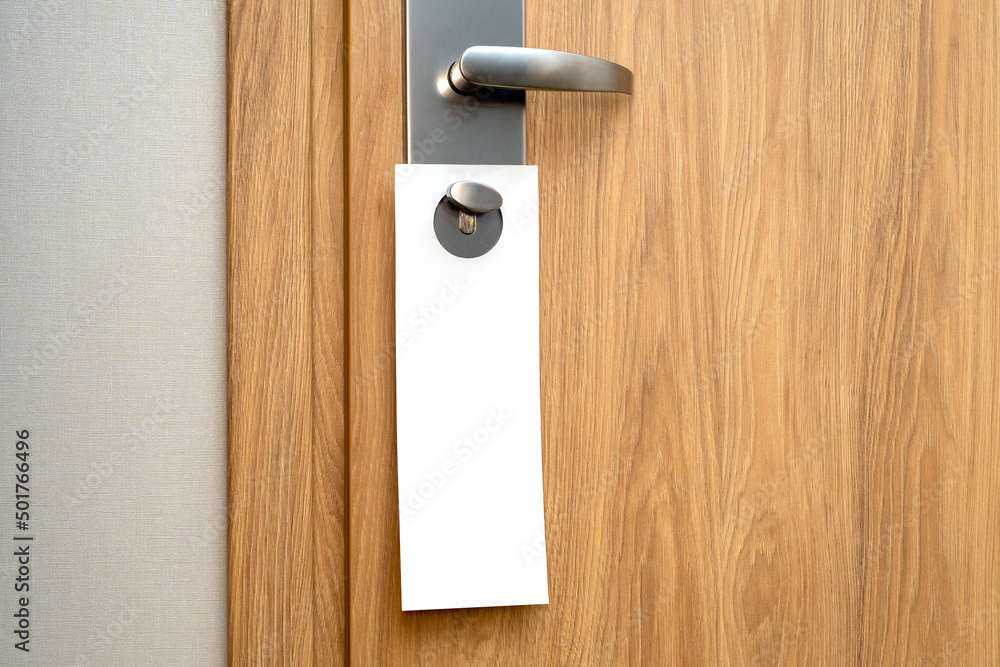 Paper blank label as mockup on door handle at the hotel. Wooden pine ...