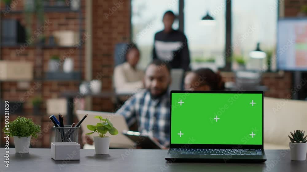 Office desk with green screen on laptop computer in workplace, mockup ...