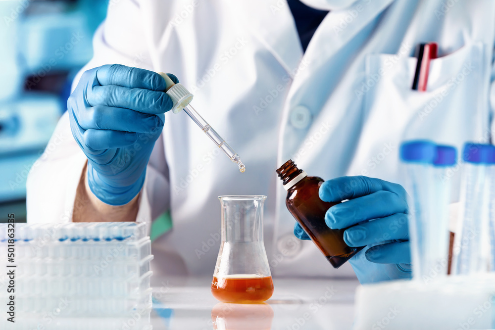Scientist researcher dosing and mixing fluids in the chemistry lab ...