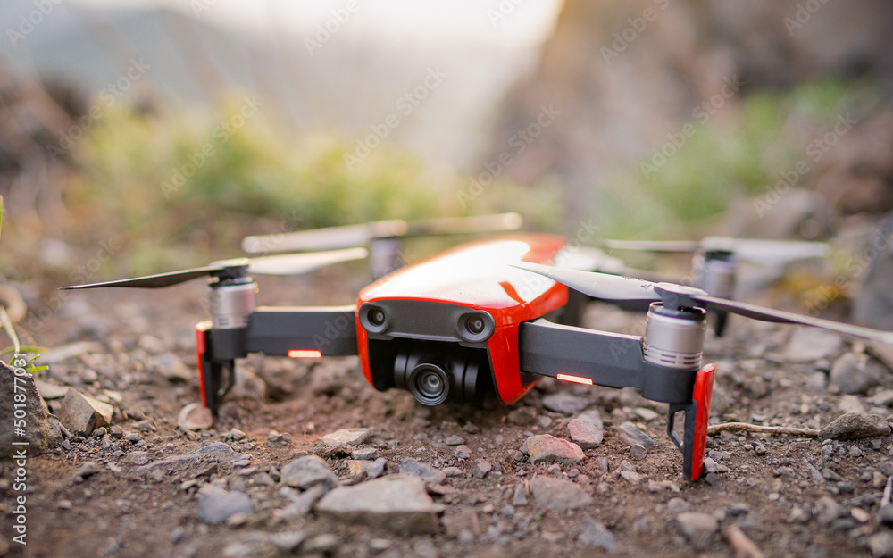 Preparation of a small drone sitting on the rock prior to take-off. Fly ...