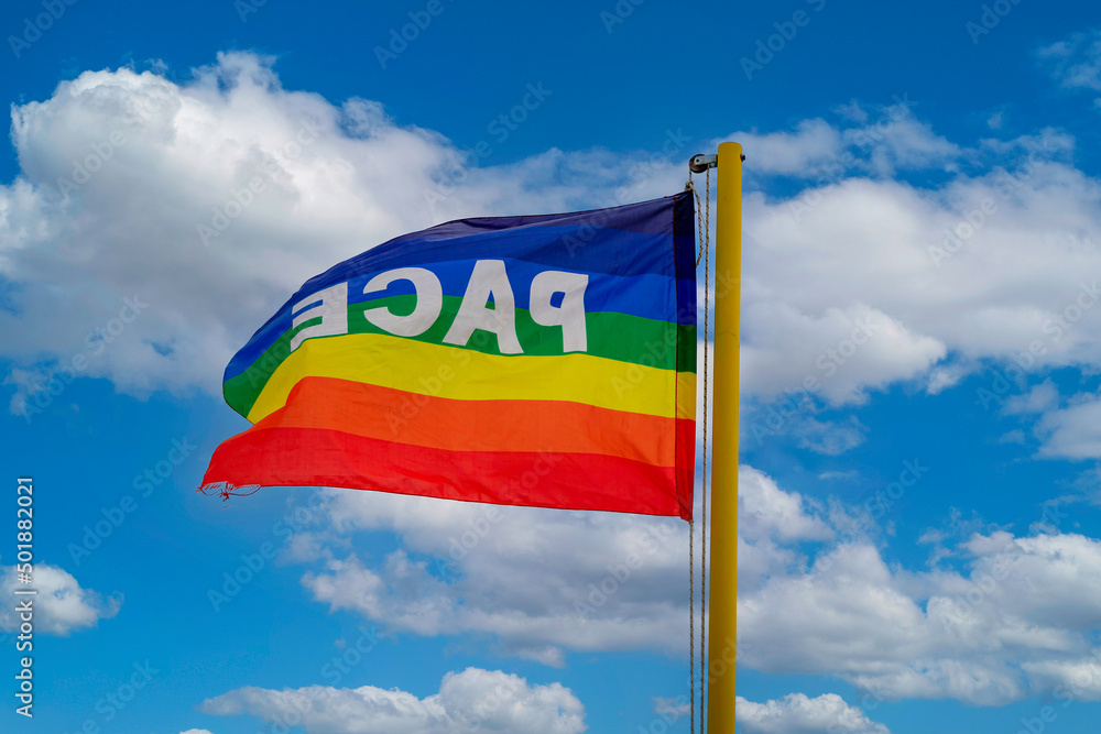 Peace flag waving. The flag in the colors of peace flutters against the ...