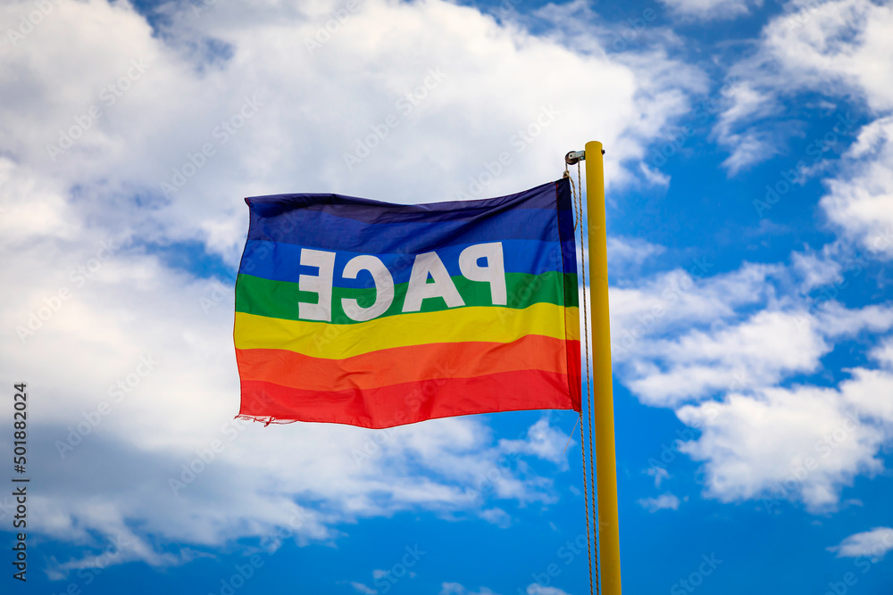 Peace flag waving. The flag in the colors of peace flutters against the ...