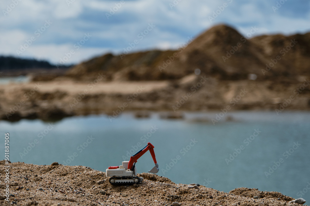 Foto Stock Small plastic toy excavator with bucket working on sand ...