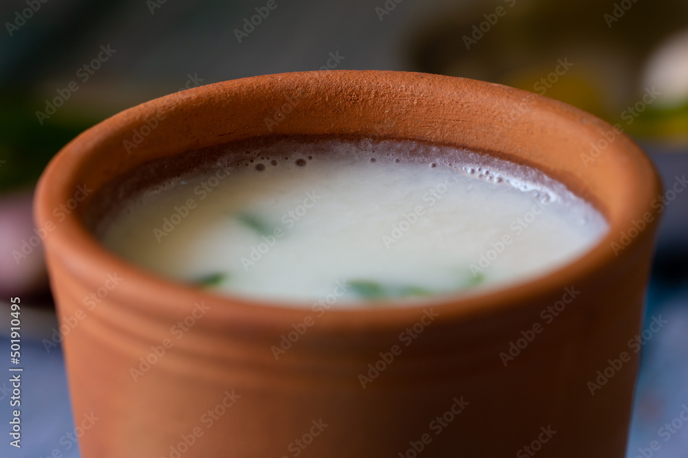 Fermented rice mixed with curd in a clay tumbler. Traditional South ...