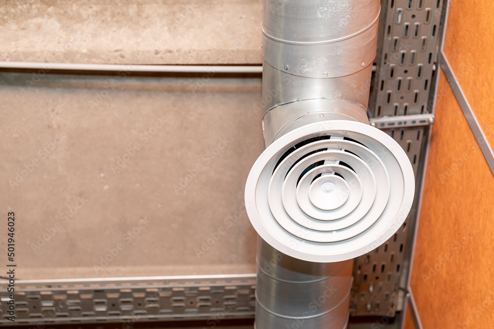 Round anemostat on a galvanized duct pipe. Industrial ventilation ...