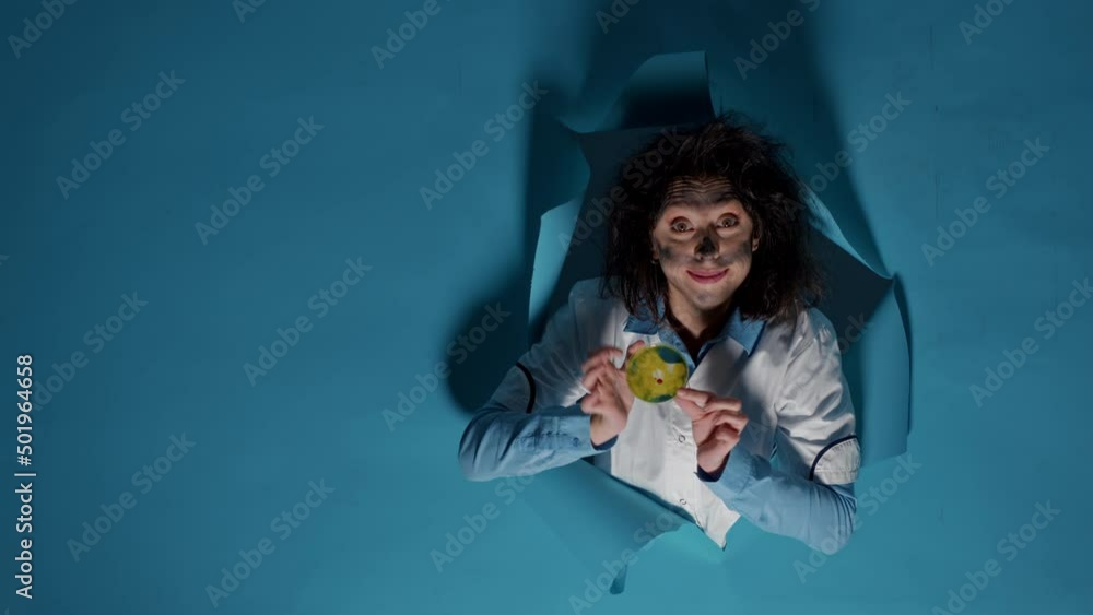 Insane funny scientist studying petri dish with liquid substance, doing ...