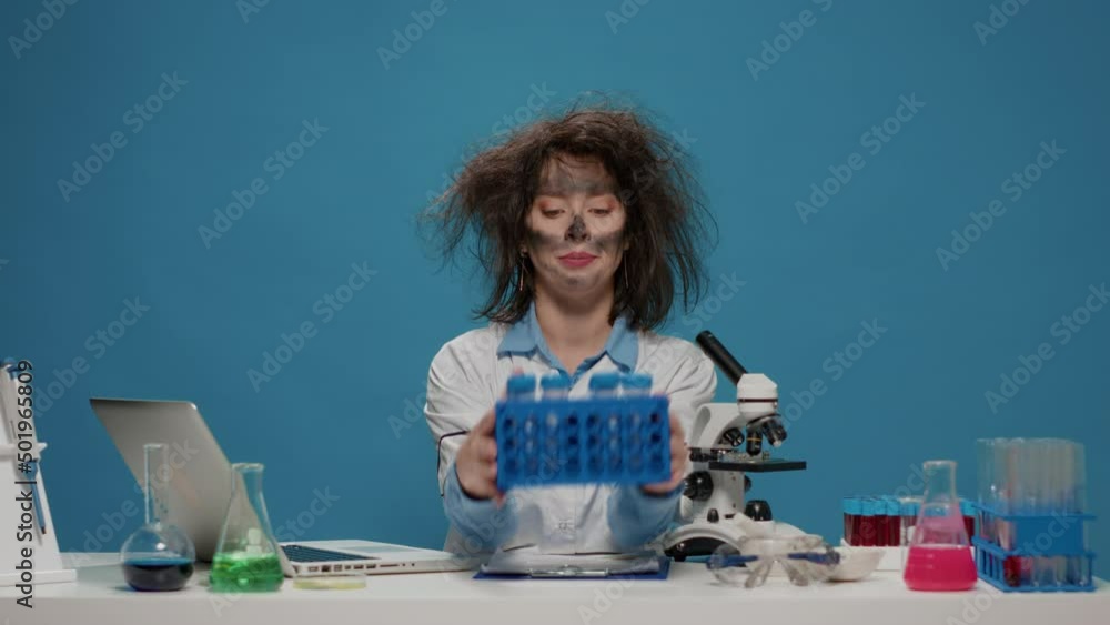 Stockvideo Funny insane female scientist looking at test tubes on desk ...