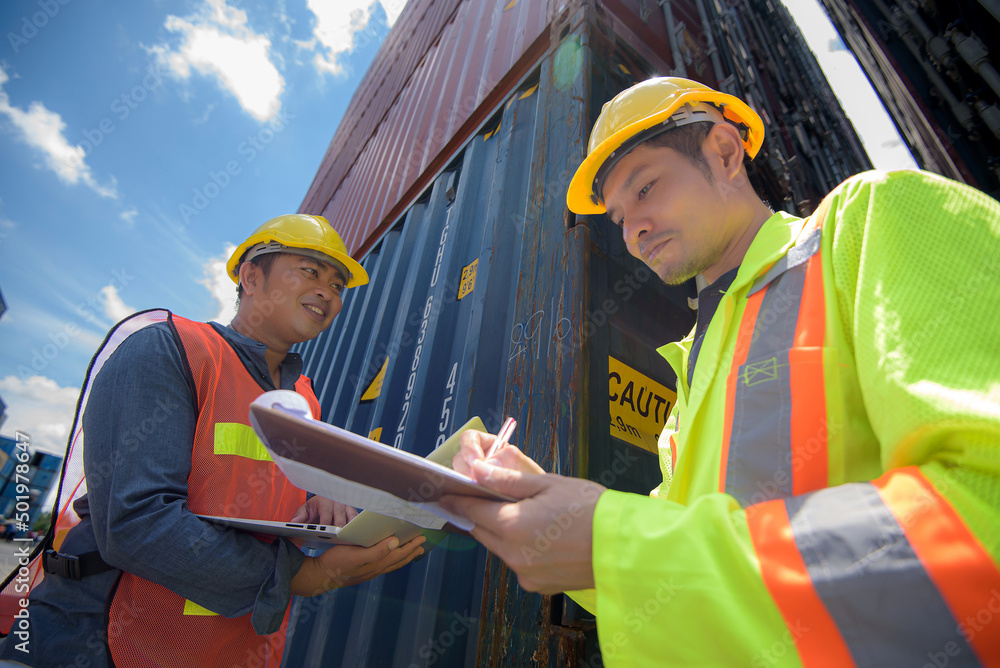 Engineer men wearing yellow hardhat standing near forklift cargo at the ...